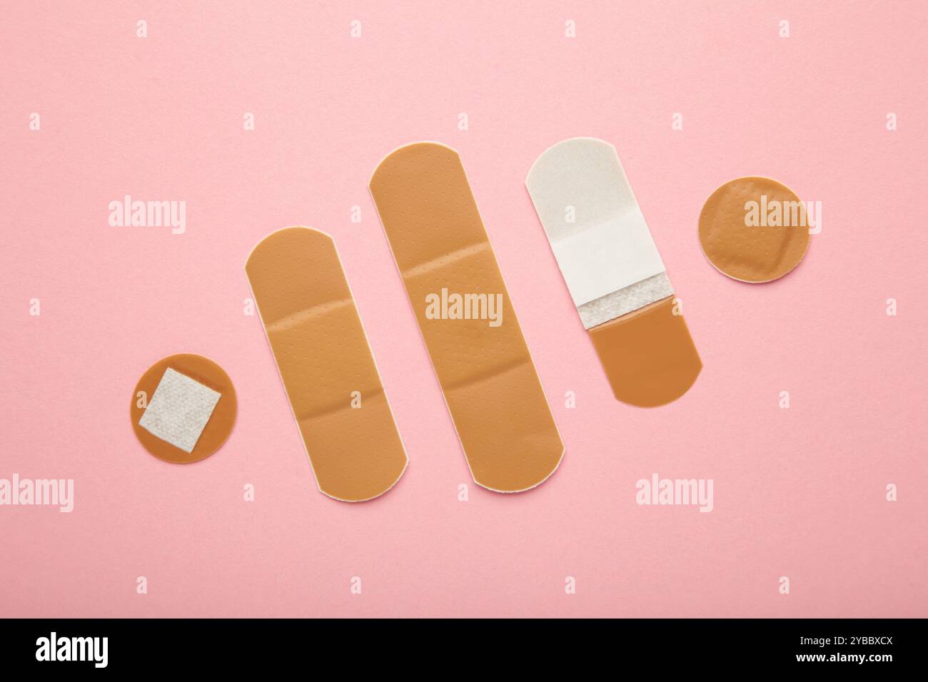 Beige adhesive bandages on pink background. Medical plasters. Top view ...