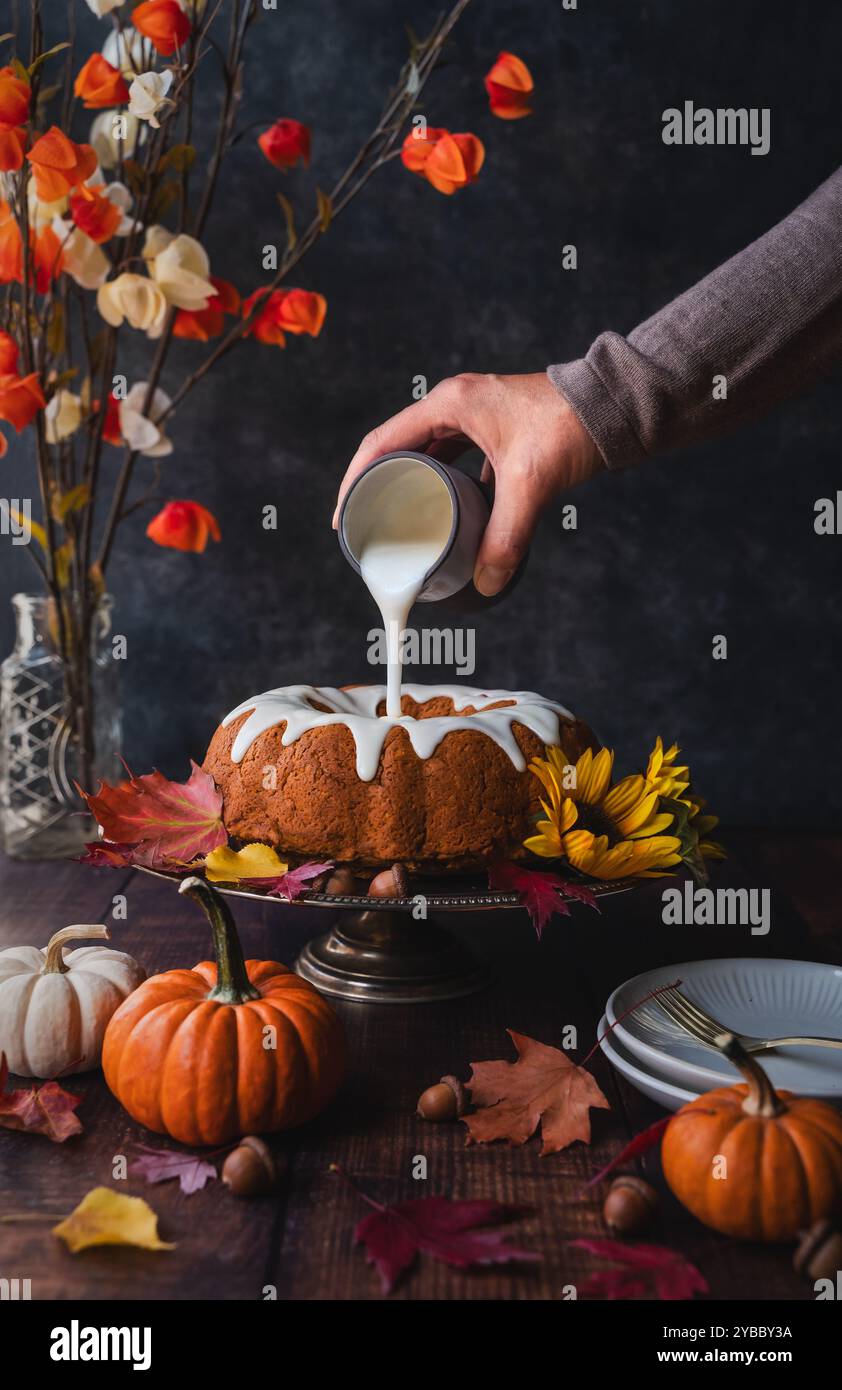 Hand pouring icing glaze on pumpkin spice bundt cake for fall Stock ...