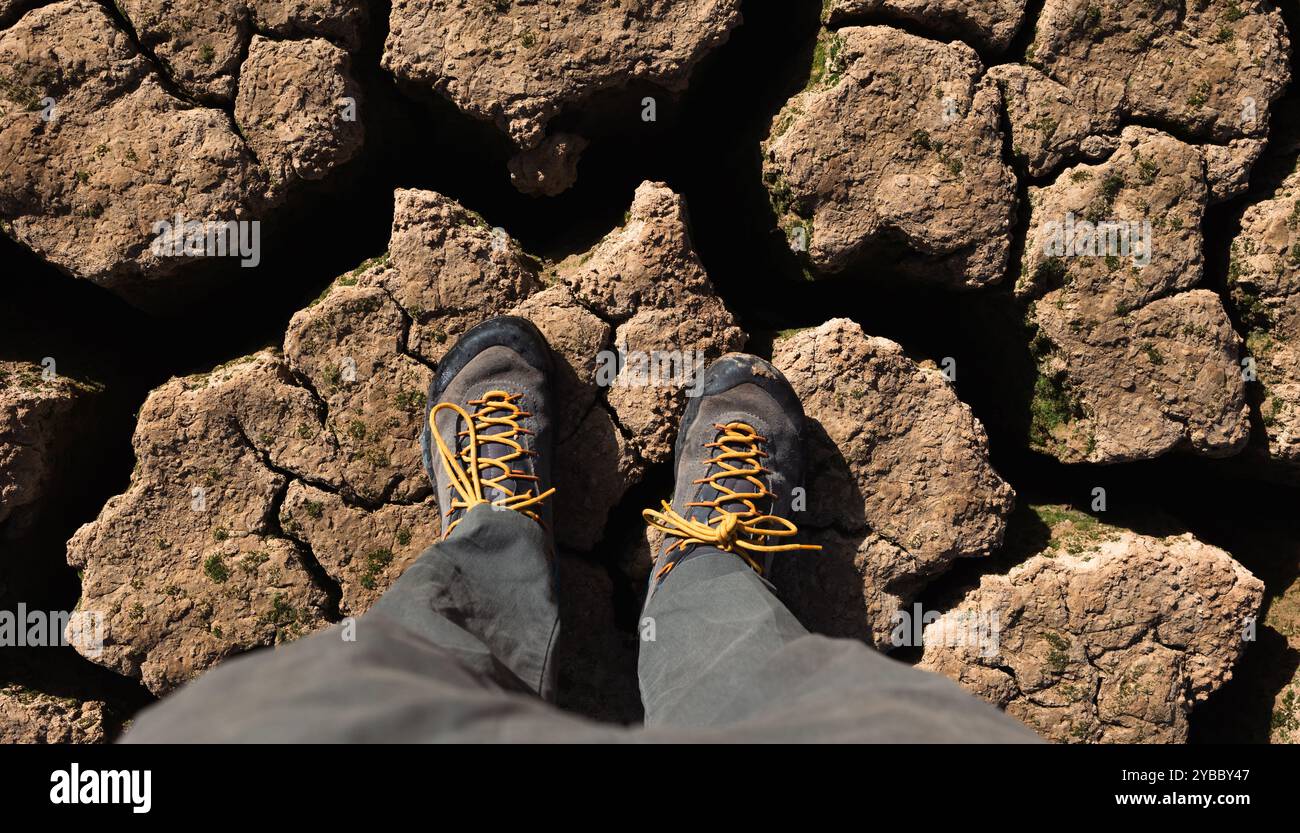 Feet on earth cracked by drought, climate change Stock Photo - Alamy