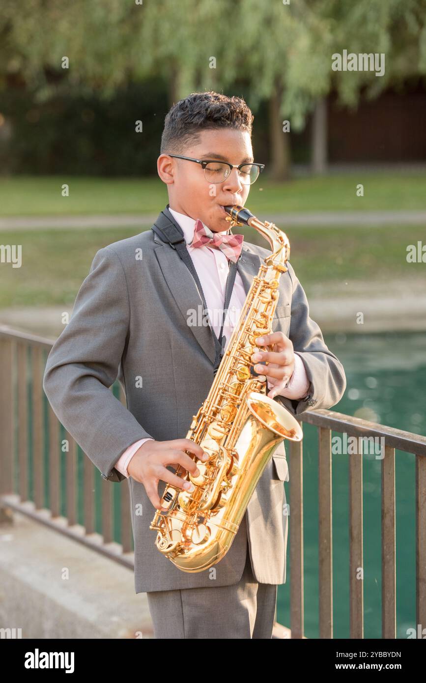 Boy playing the saxophone outside Stock Photo - Alamy