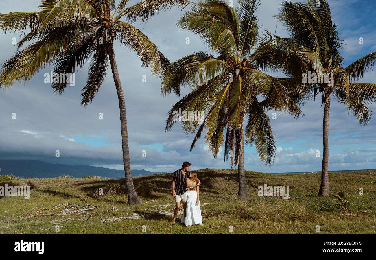 Couple in love standing near coconut trees Stock Photo - Alamy