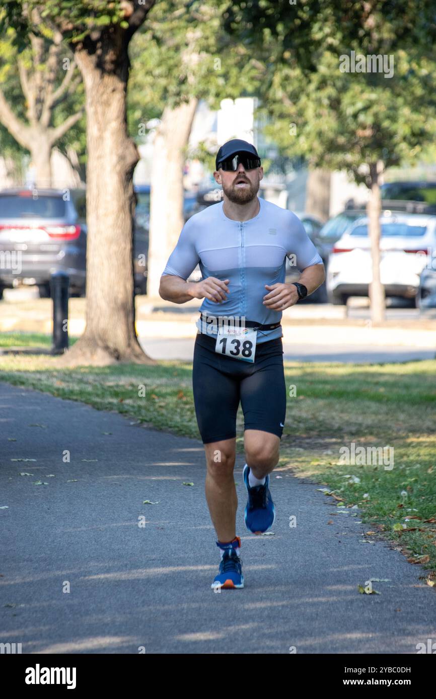 Male athlete running in a triathlon, wearing sunglasses and race gear ...