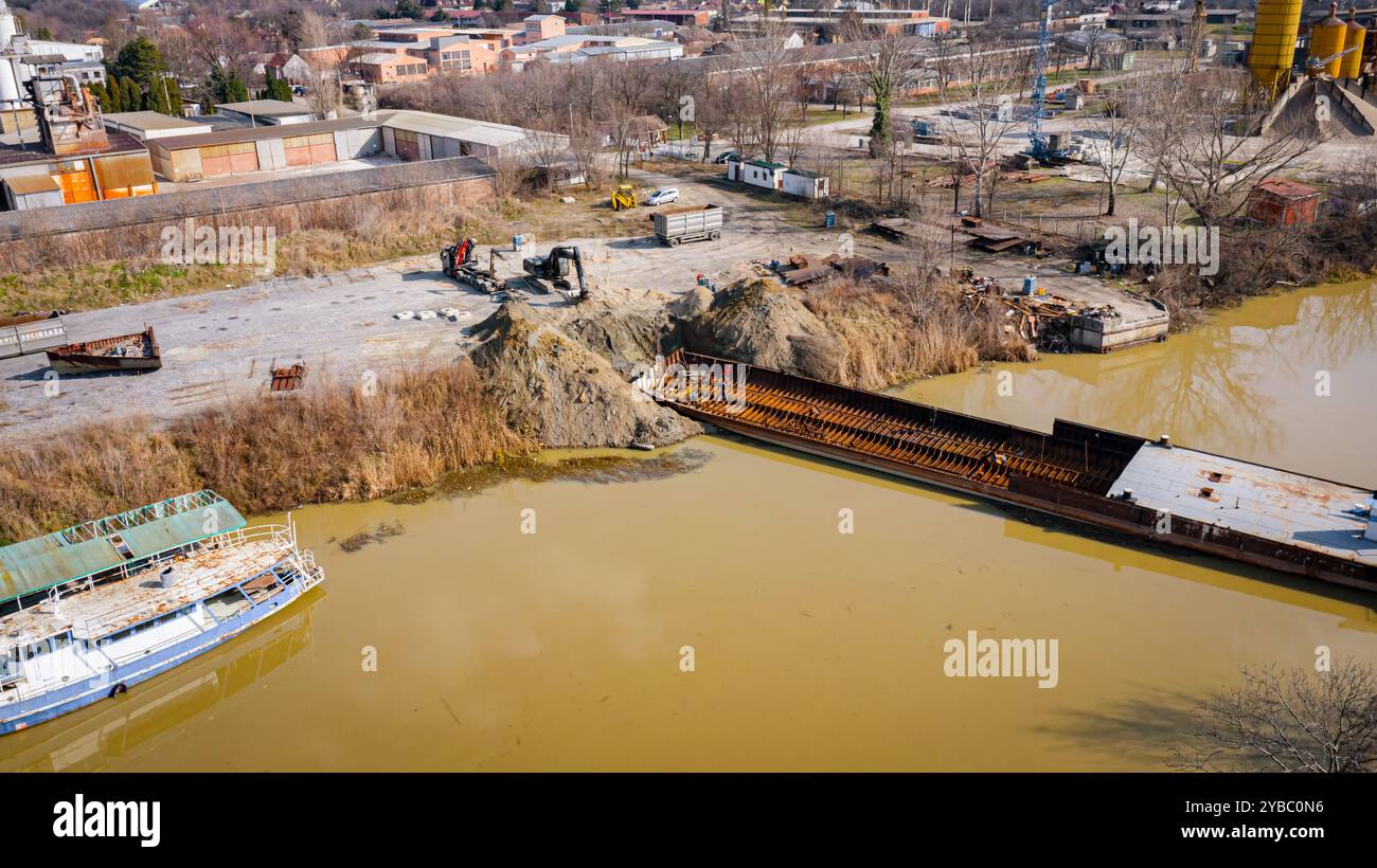 Above top view on workers as they cutting old large vessel, barge ...