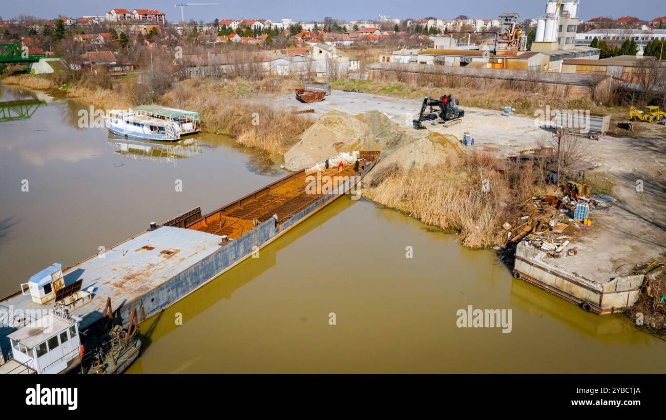 Above view over excavator, tow truck and tugboat as they pull out part ...