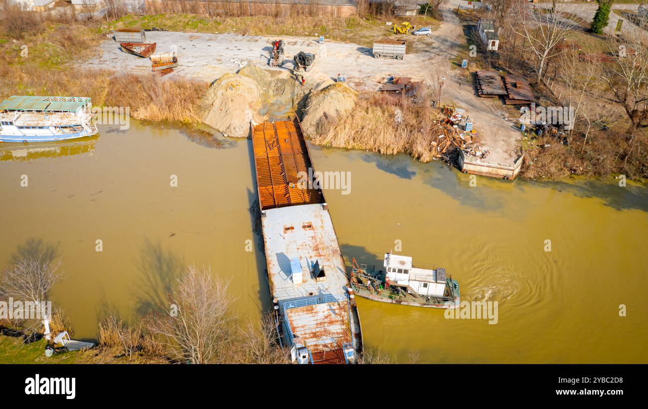 Above view over excavator, tow truck and tugboat as they pull out part ...