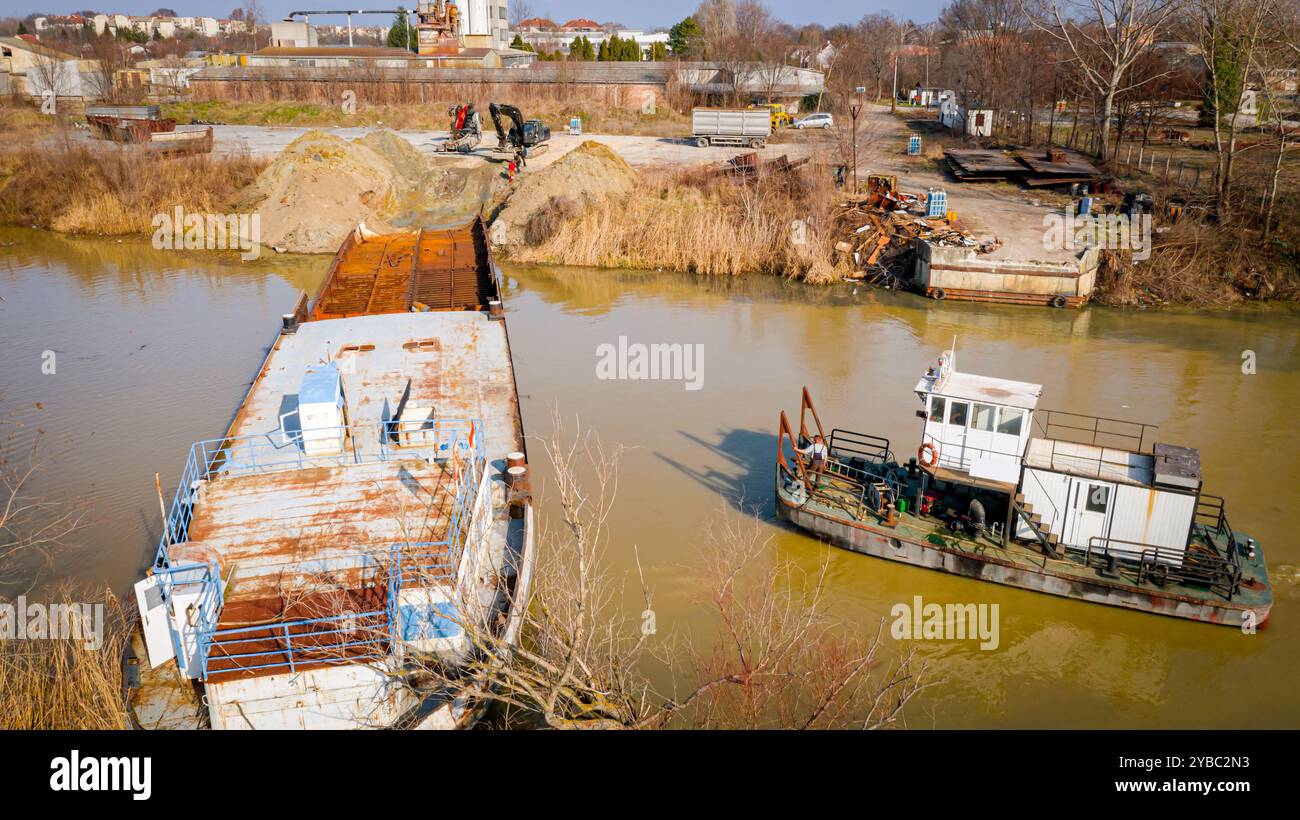 Above view over excavator, tow truck and tugboat as they pull out part ...