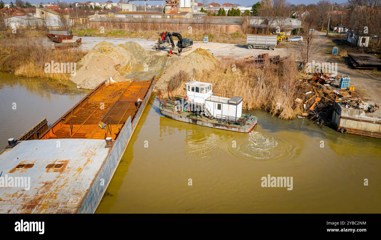 Above view over excavator, tow truck and tugboat as they pull out part ...