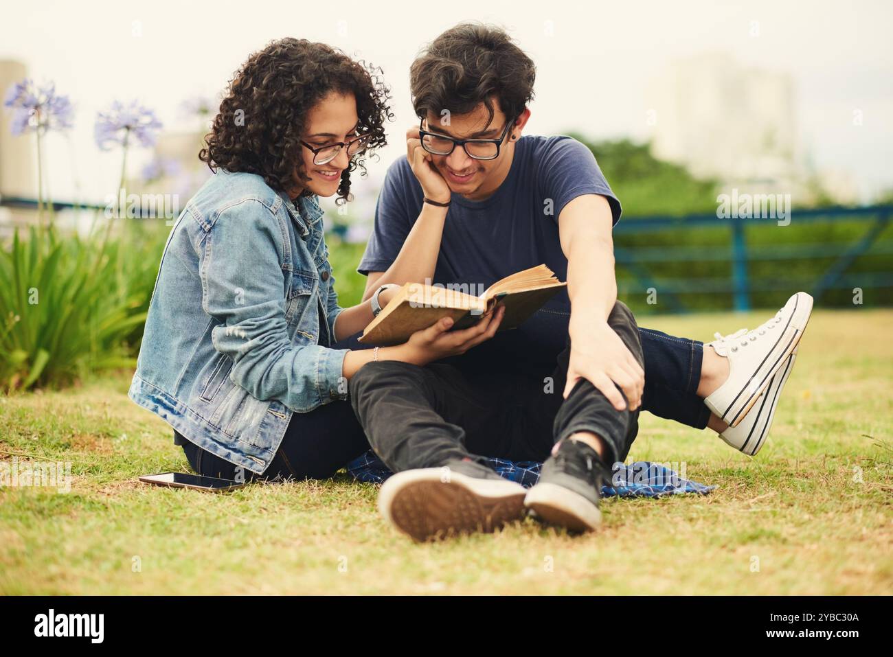 Couple, teenager and book outdoor for relax, bonding and reading ...