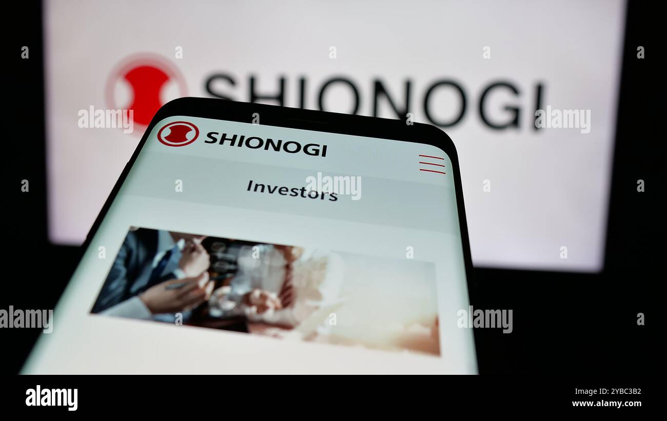 Smartphone with website of Japanese pharmaceutical company Shionogi Co. Ltd. on screen in front ...