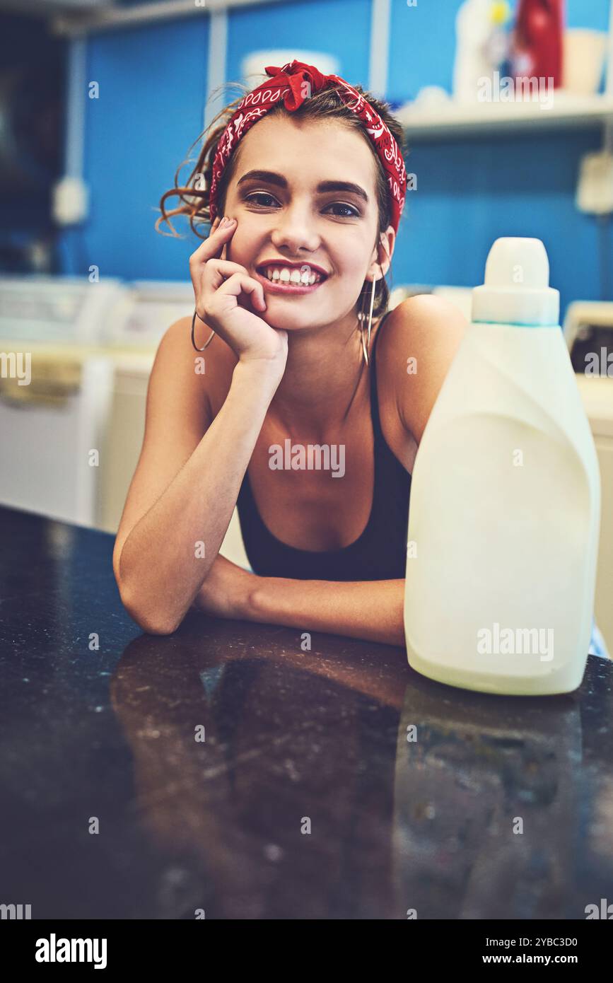 Portrait, smile and woman with detergent, laundry room and confident ...