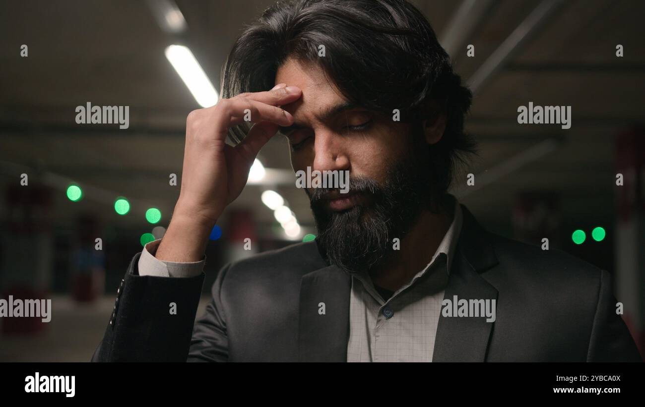 Stressed frustrated Indian man in underground parking lot suffering ...