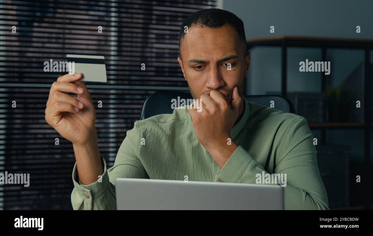 Puzzled confused african american man pay remote credit card using ...