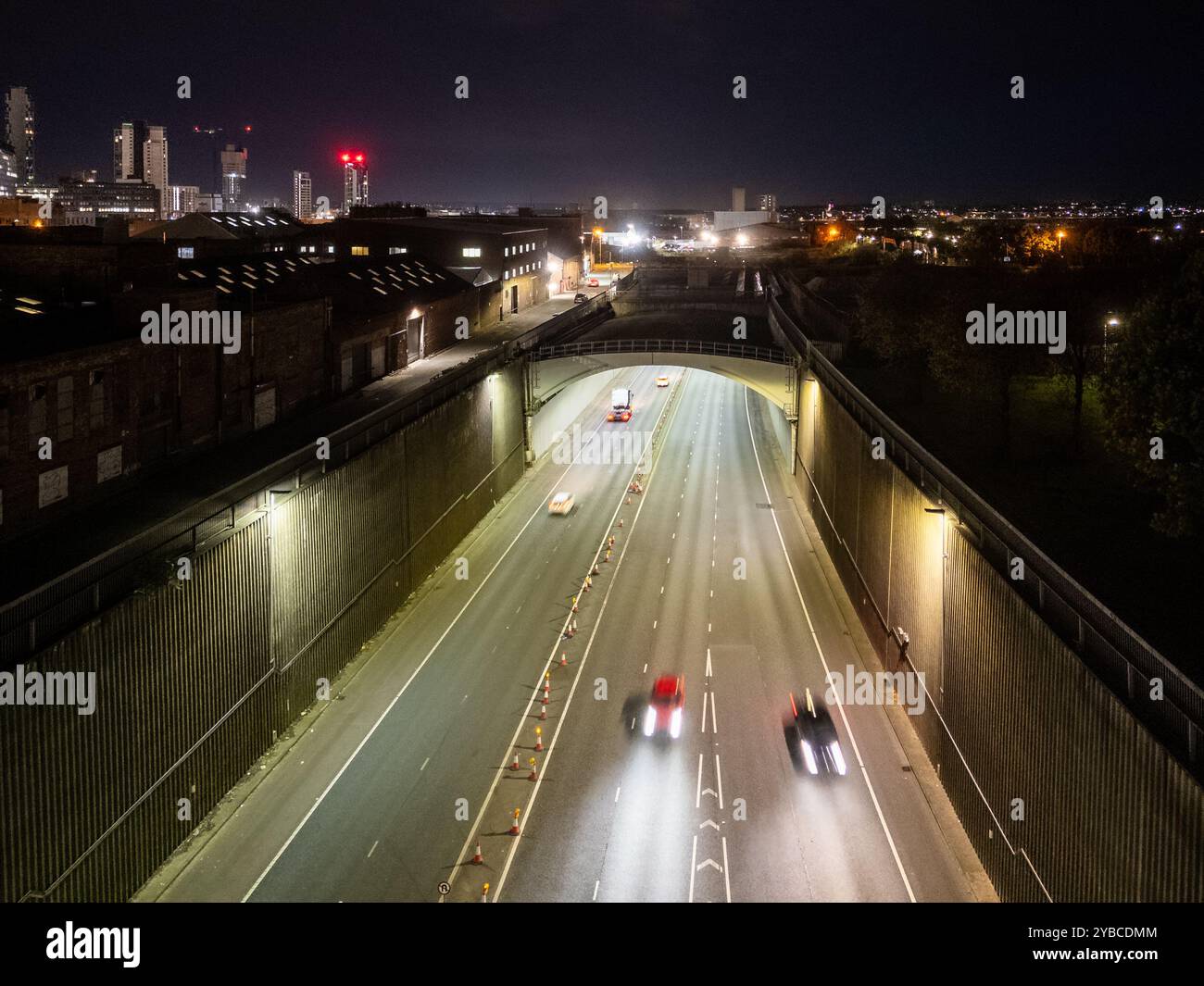 Cars driving on a highway surrounded by high walls to reduce noise ...