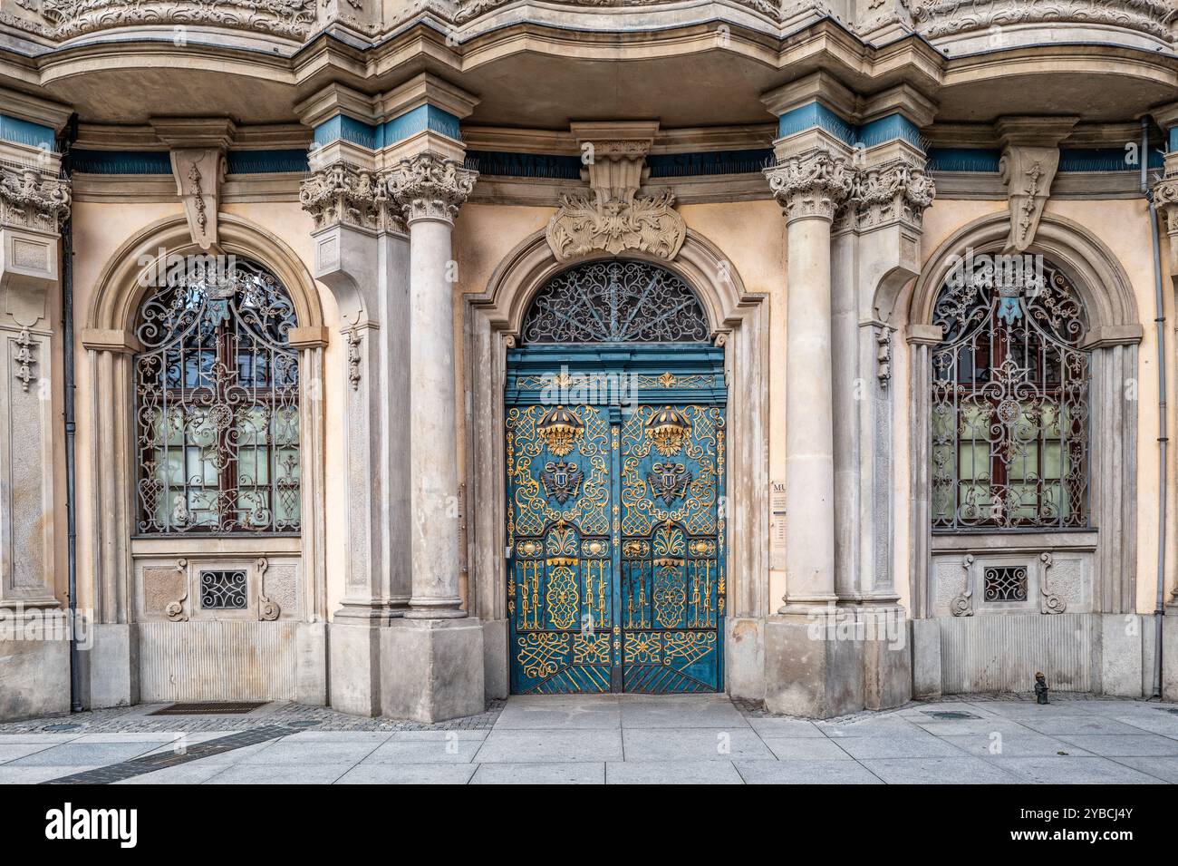 A beautifully ornate blue iron gate accentuates the entrance of a ...