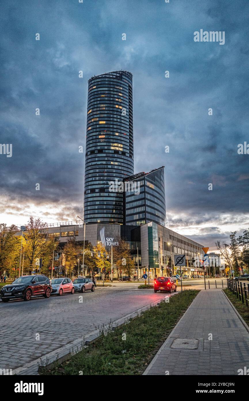 An impressive skyscraper towers over a bustling city street at twilight ...