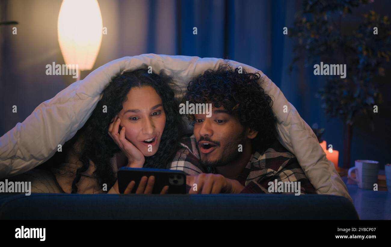 Happy family relaxed multiracial couple Indian man and Arabian woman at evening late night in ...