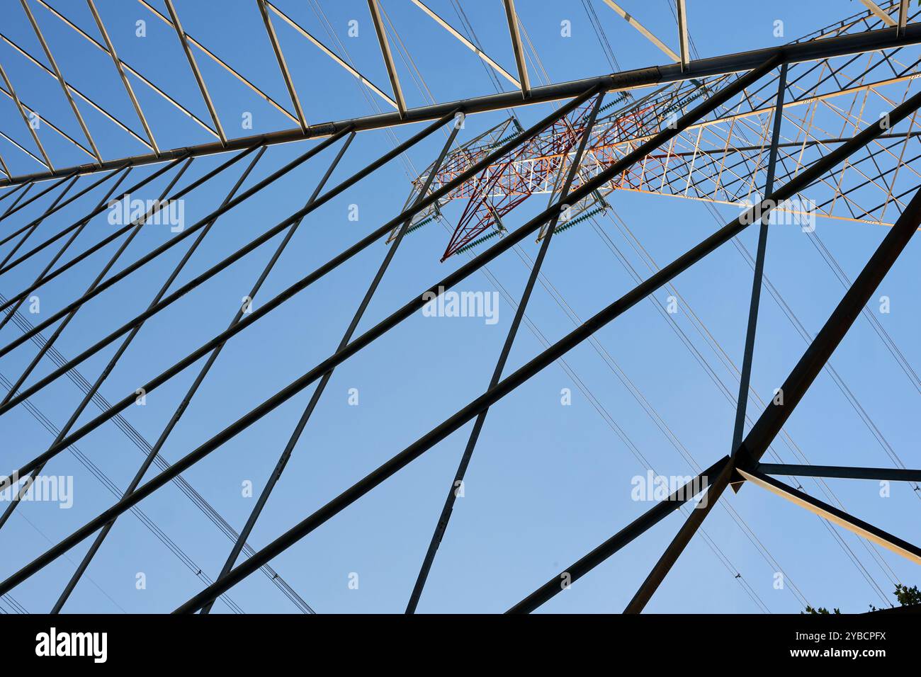 Low angle view of electrical power poles against the sky, emphasizing ...