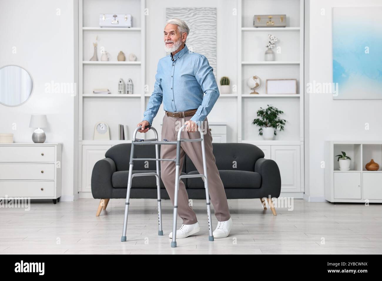 Senior man using walking frame at home Stock Photo - Alamy