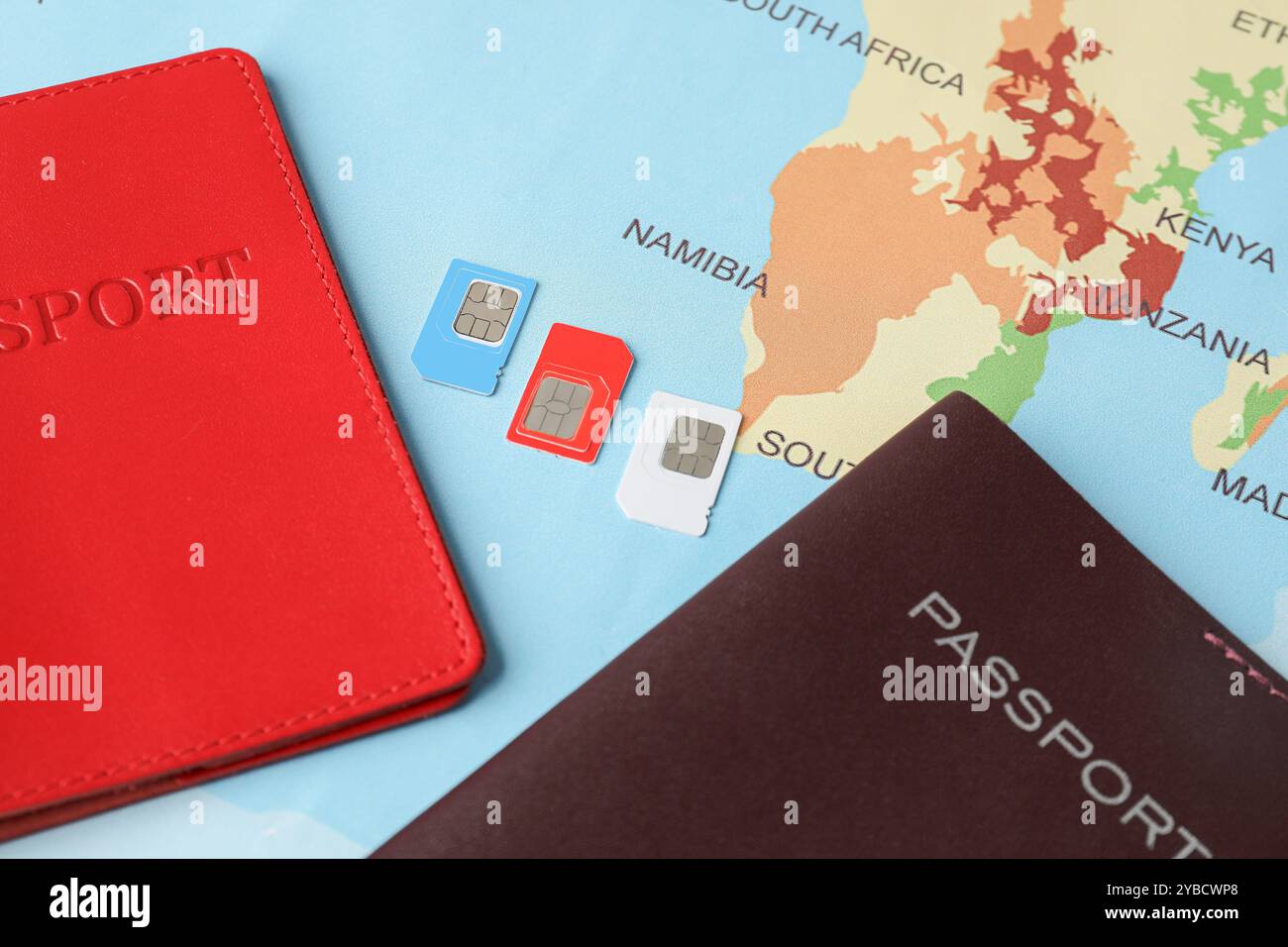 Passports and SIM cards on world map Stock Photo - Alamy