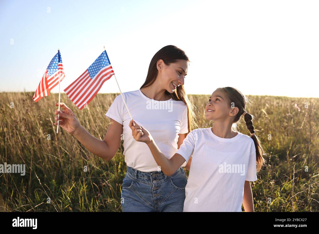 Happy mother and daughter with flags of USA outdoors Stock Photo - Alamy