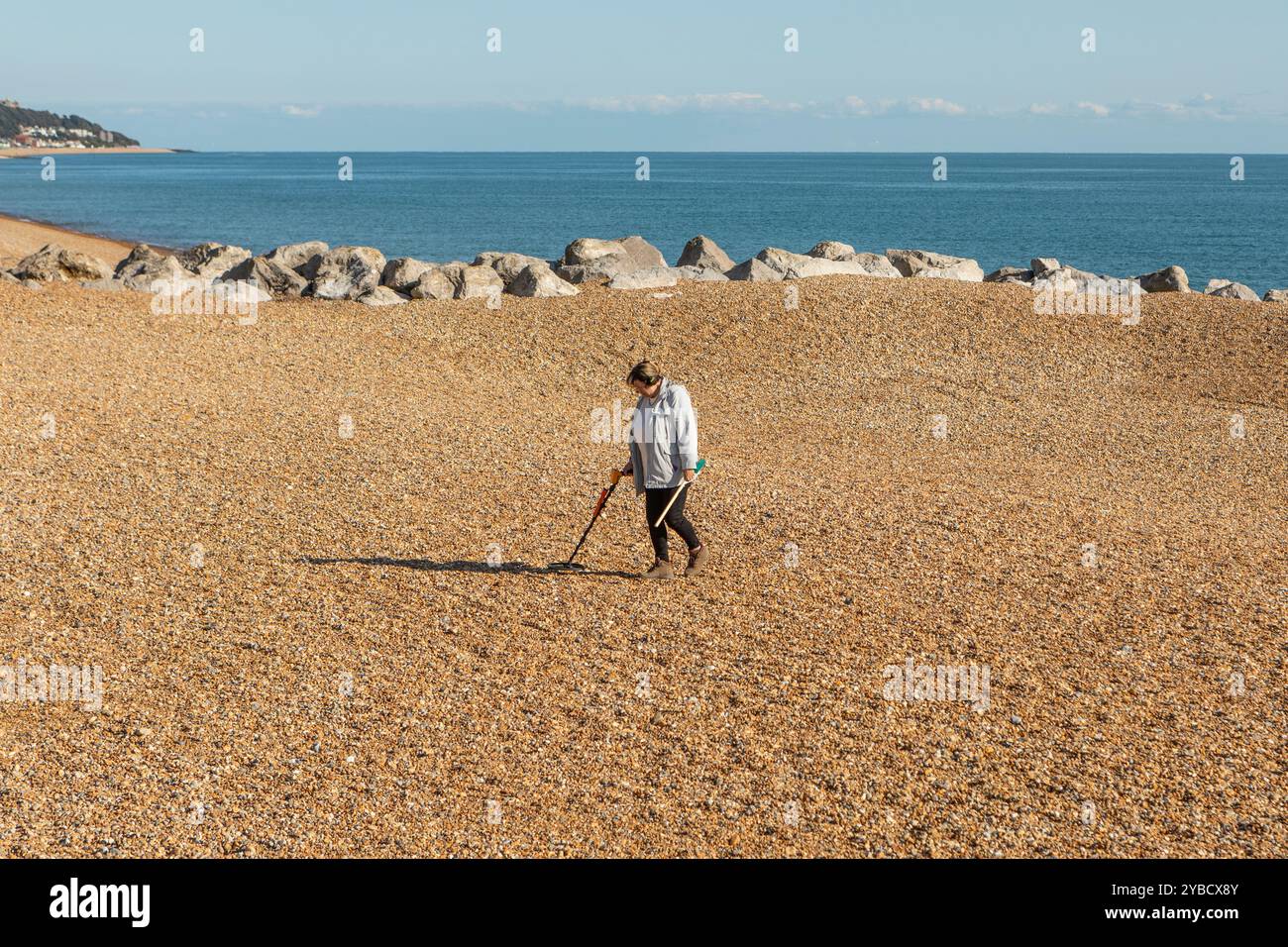 A lady with a metal detector on a shingle beach Stock Photo - Alamy