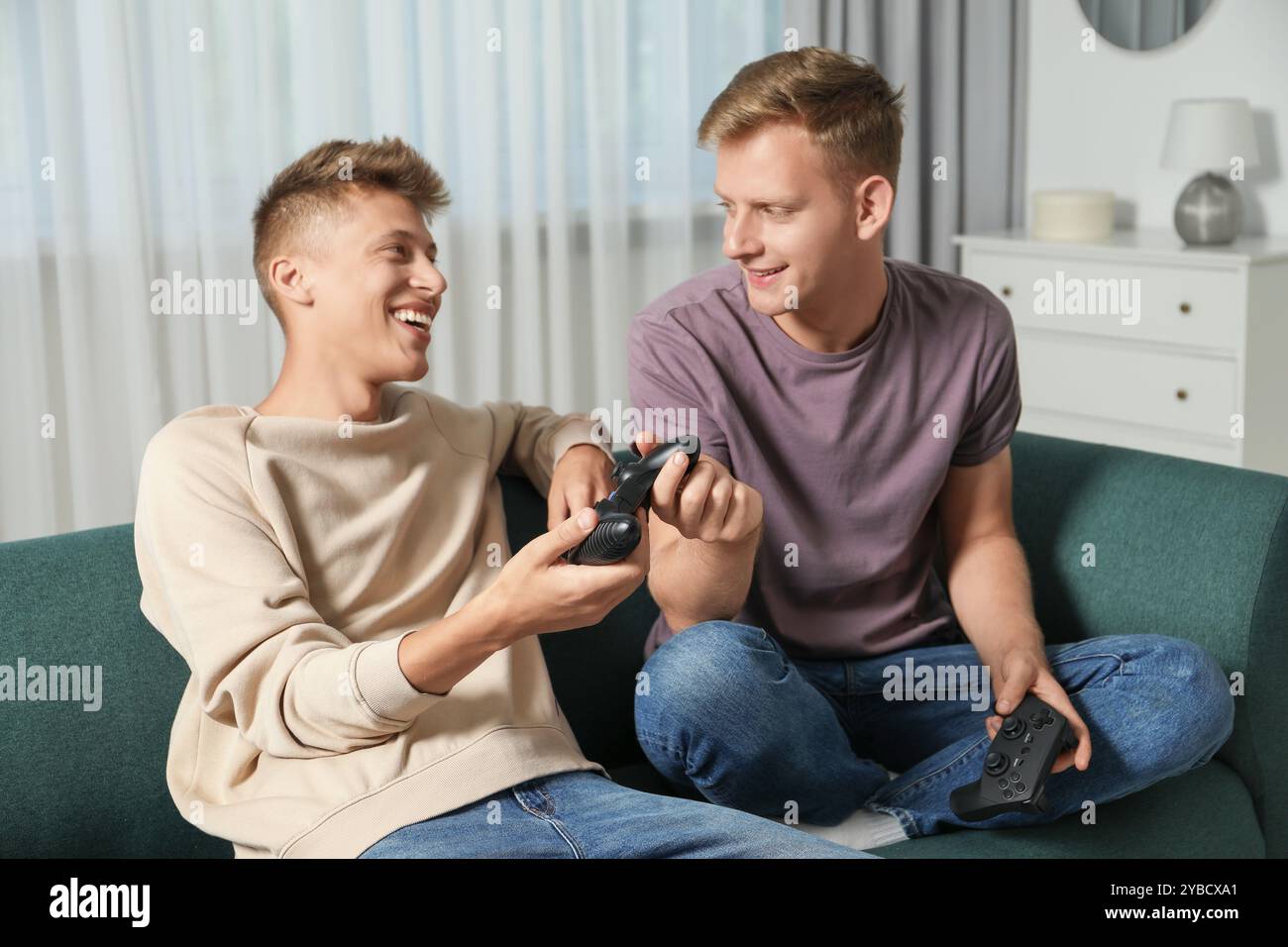 Happy brothers playing video game at home Stock Photo - Alamy