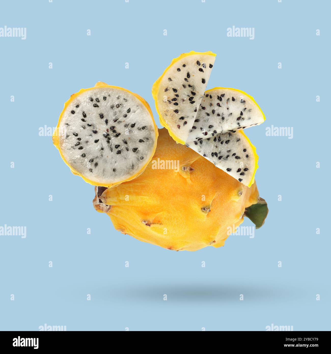 Yummy yellow pitaya fruits falling on light blue background Stock Photo ...
