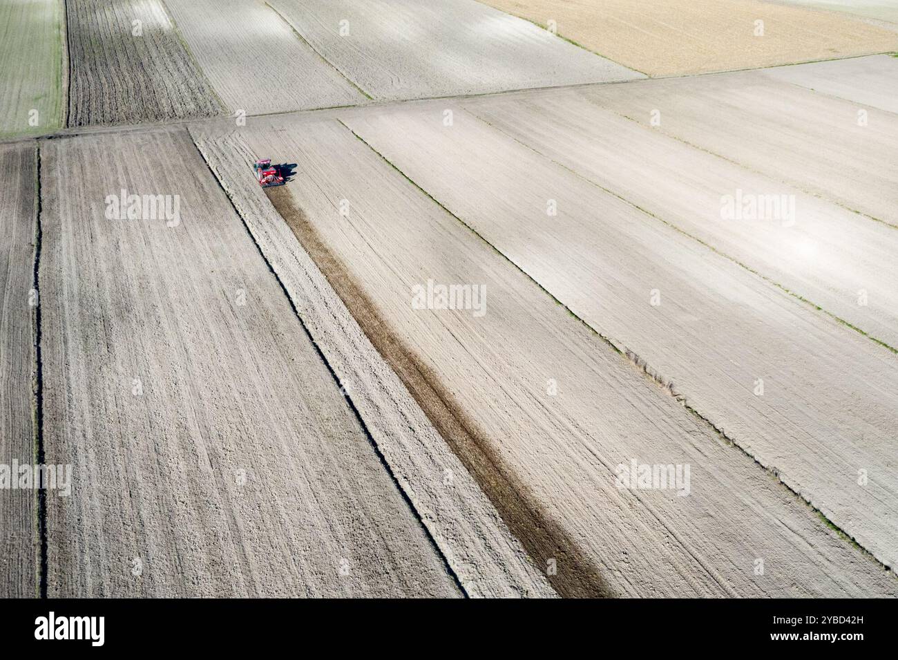 Frmers plow soil in a tractor on an agricultural field as the planting ...