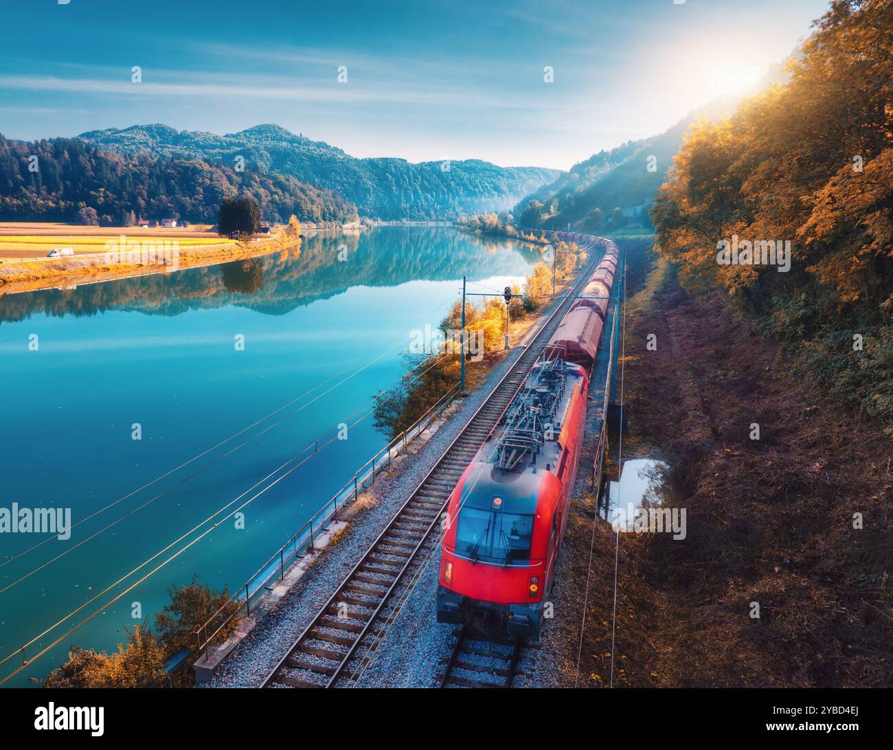 Aerial view of red high speed train moving near lake in mountains Stock ...