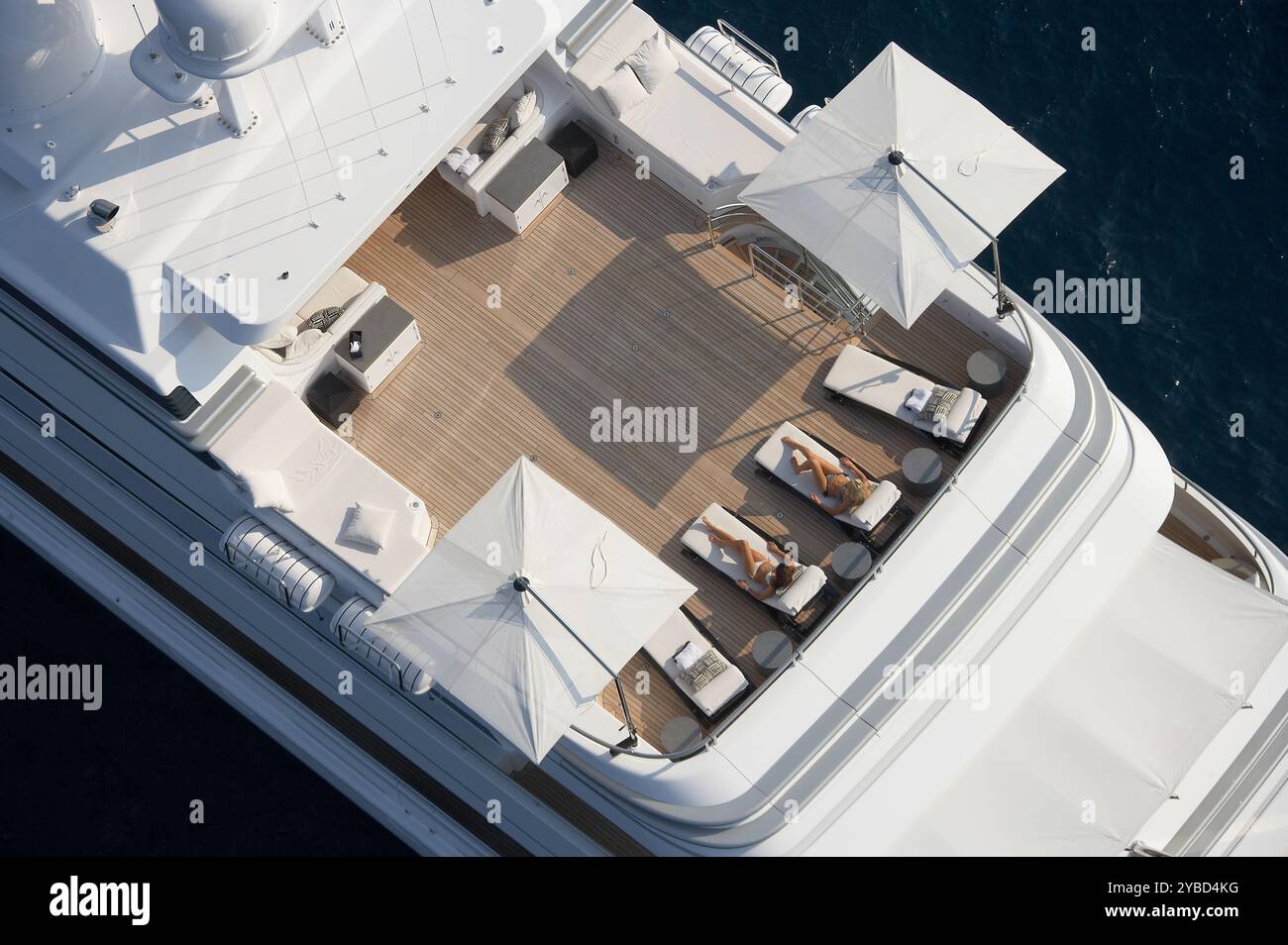 Aerial photo of superyacht teak sundeck with guests sunbathing on white ...