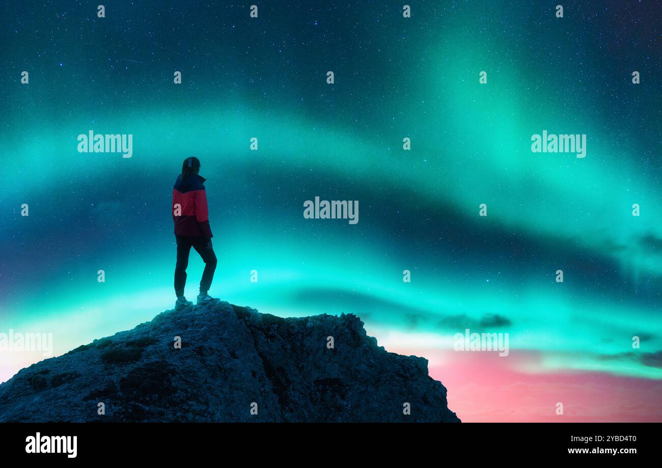Northern lights and woman on mountain peak at night. Aurora Stock Photo ...