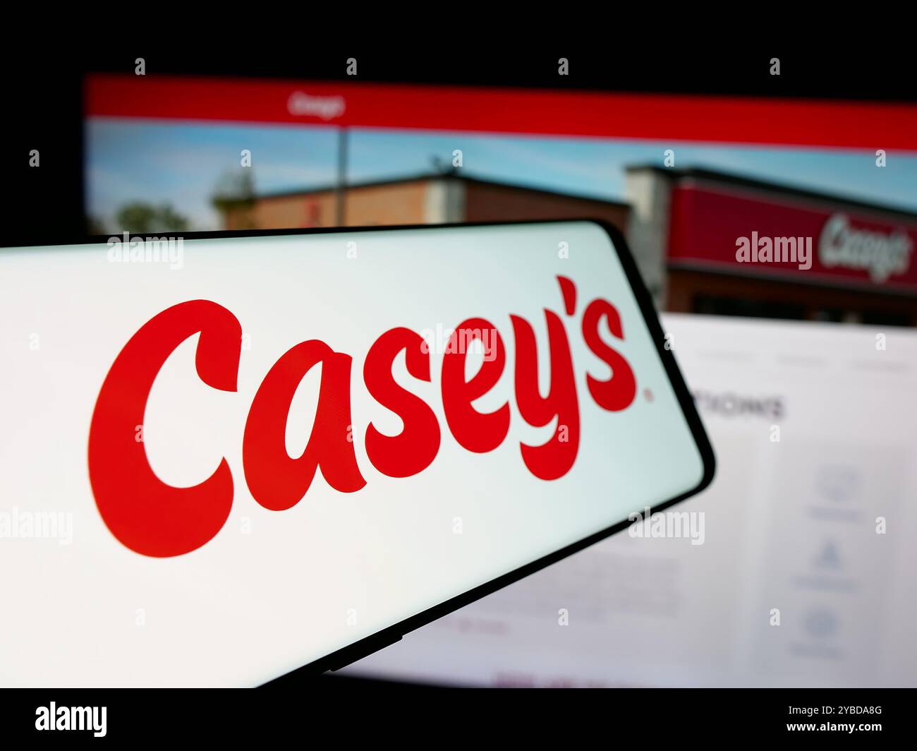 Mobile phone with logo of US company Casey's General Stores Inc. on screen in front of business ...