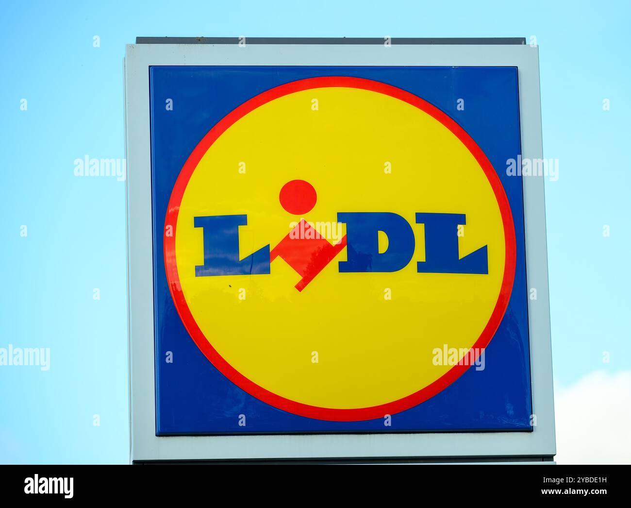 A vivid supermarket sign is prominent against the clear blue sky ...
