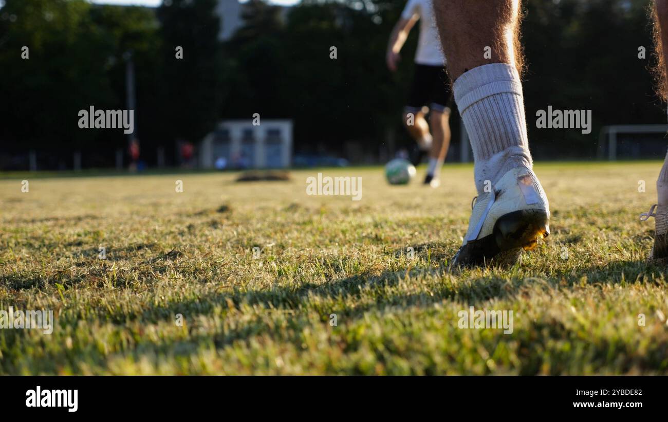 Male feet of professional footballers passing soccer ball on stadium at ...