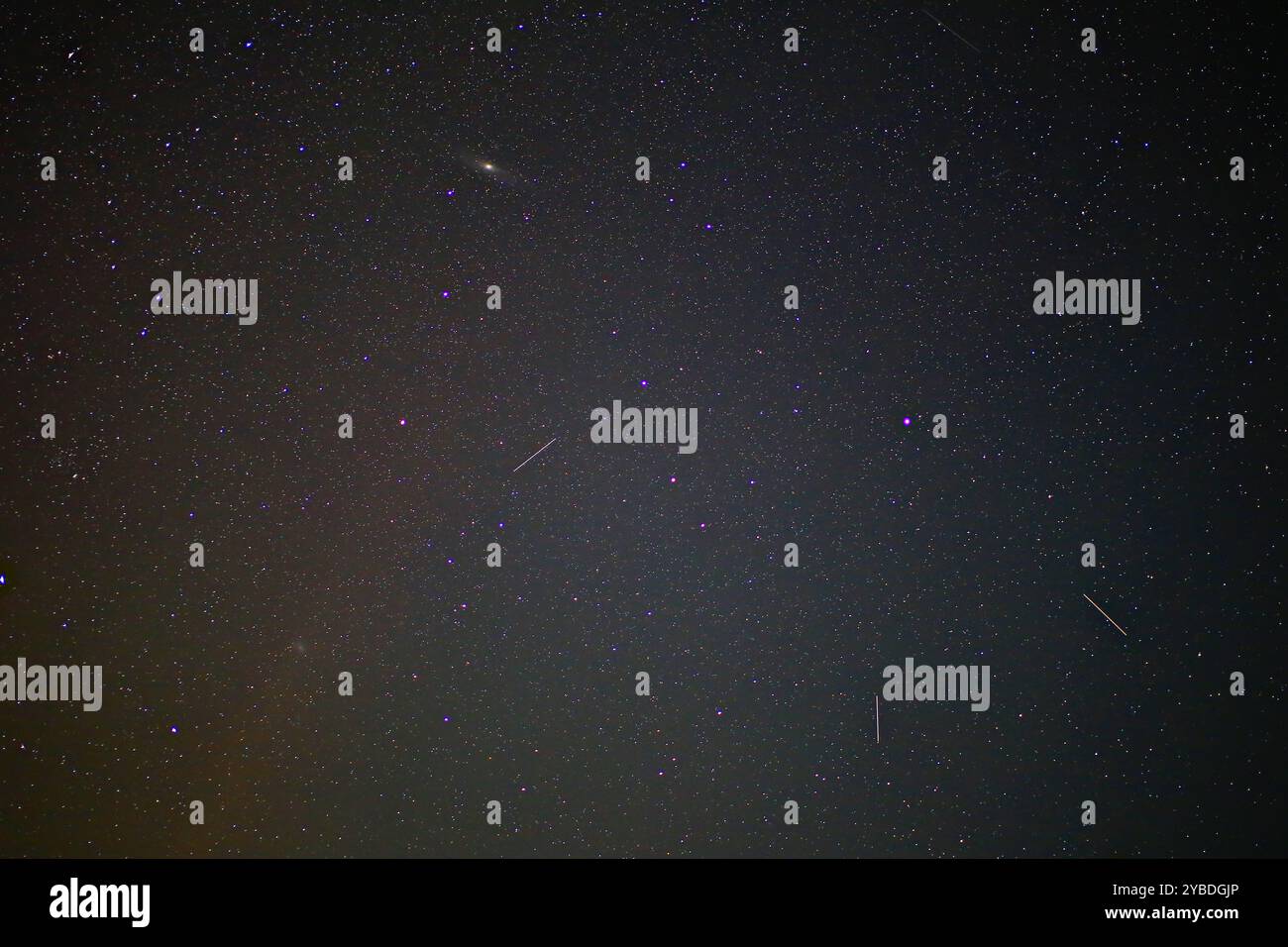 Stars and andromeda galaxy visible in a clear night sky with meteor ...