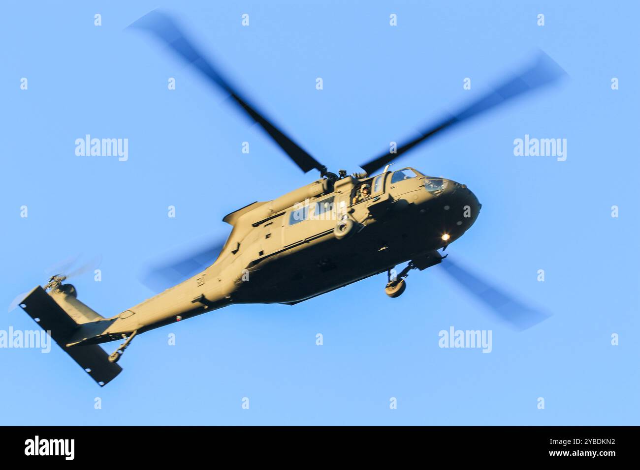 Military helicopter in flight against blue sky Stock Photo - Alamy