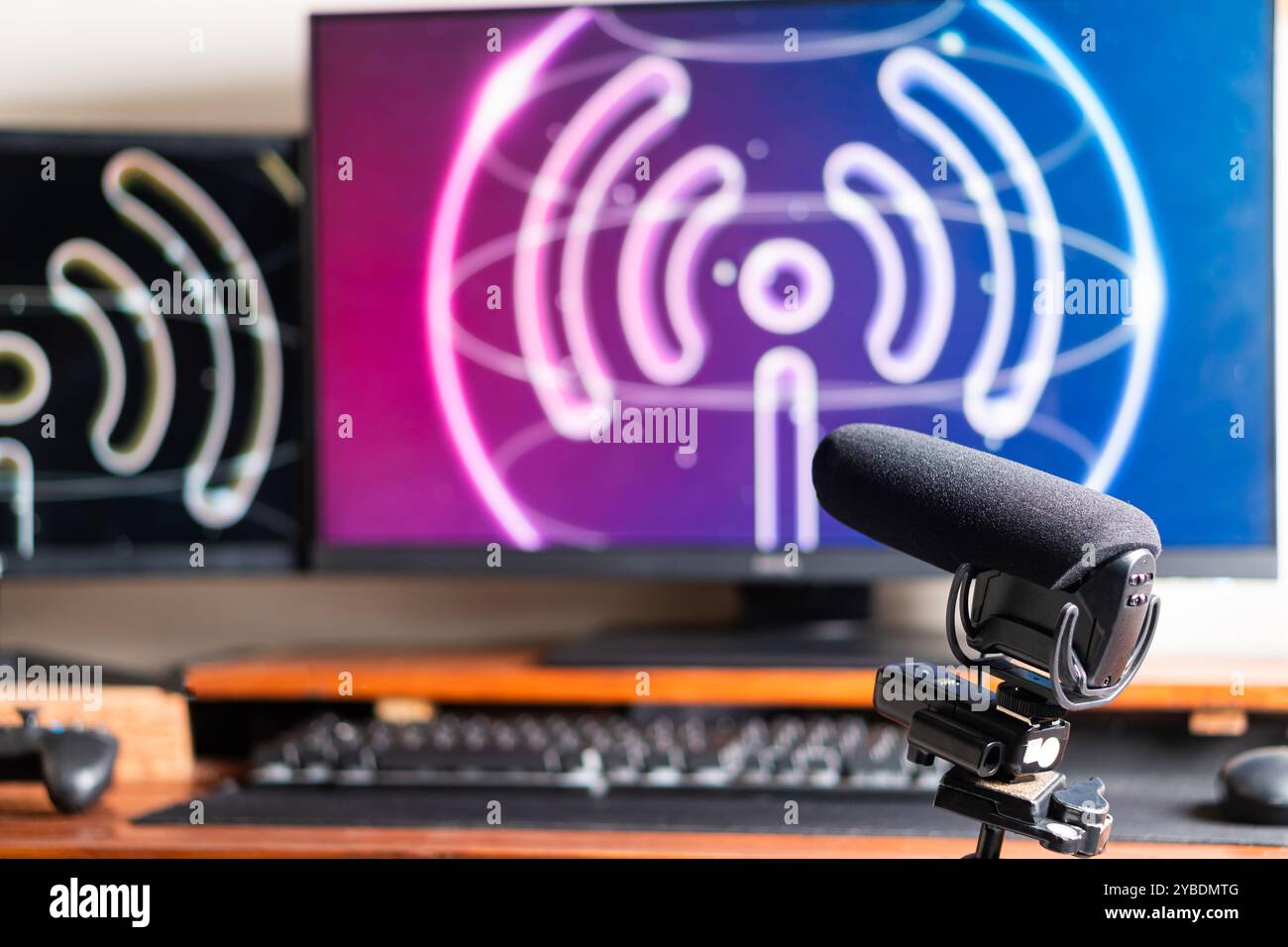 A close-up of a microphone in front of a computer setup with dual ...