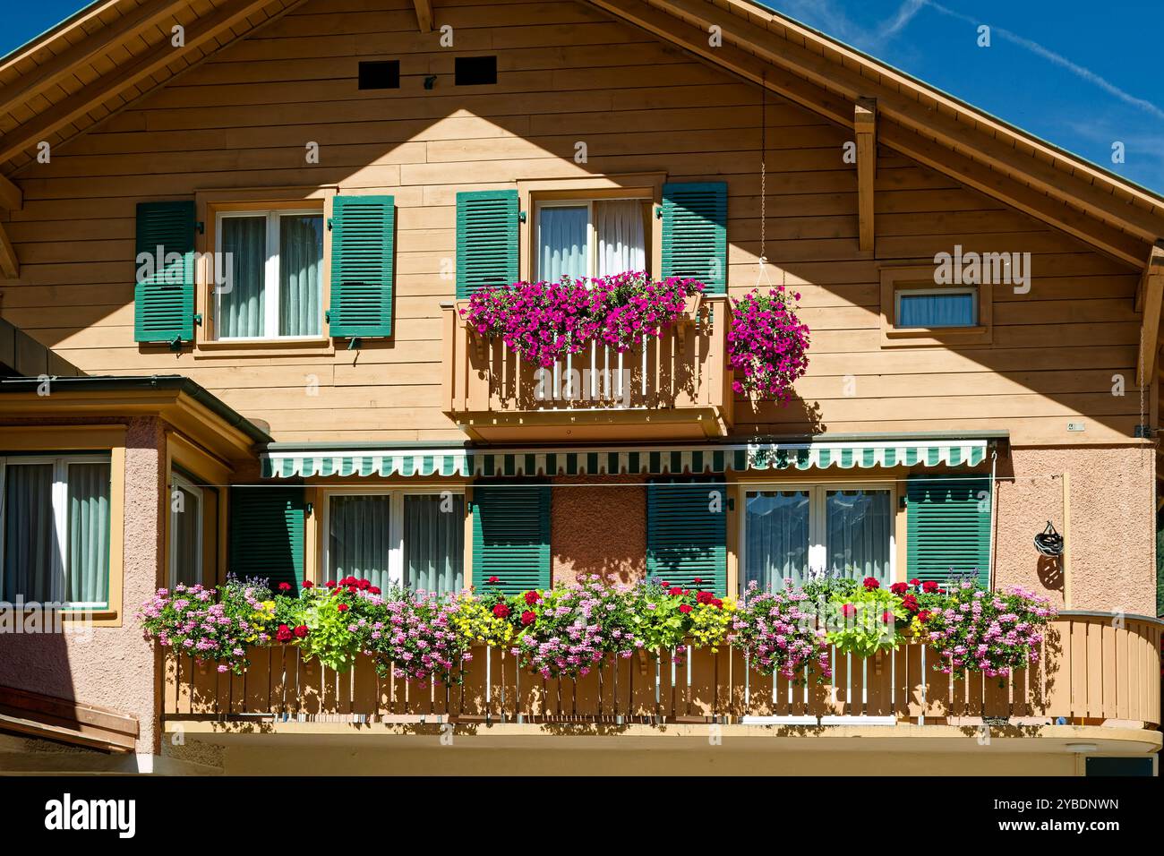 Swiss style house, many flowers, colorful, green shutters, balcony ...