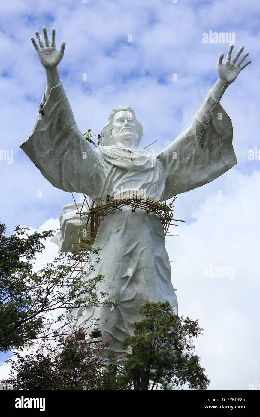 Workers take care of one of Manado popular landmarks, the giant Jesus ...