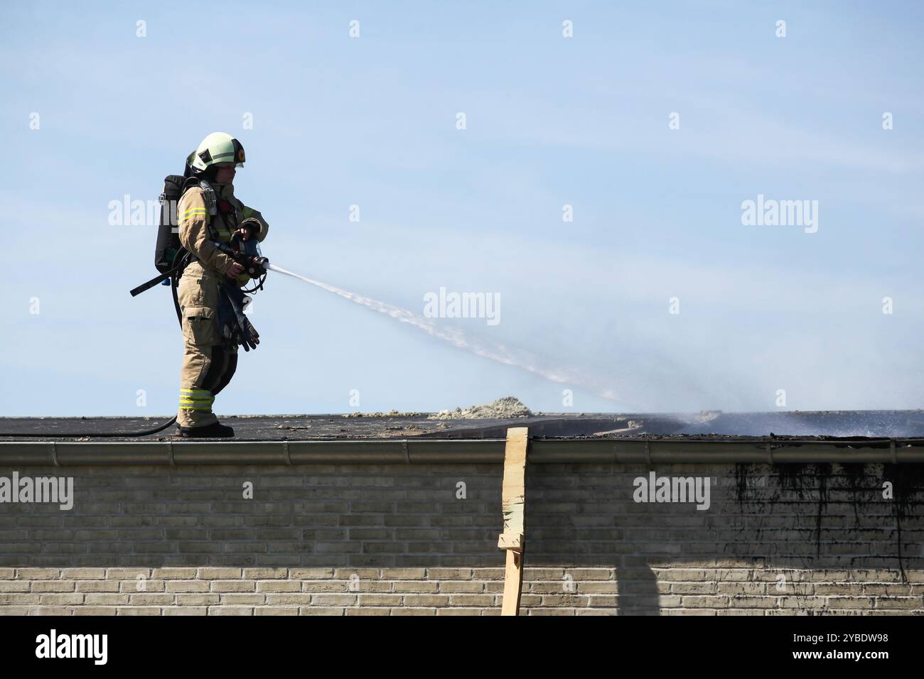 Firefighter putting out a fire in a house in Denmark Stock Photo - Alamy