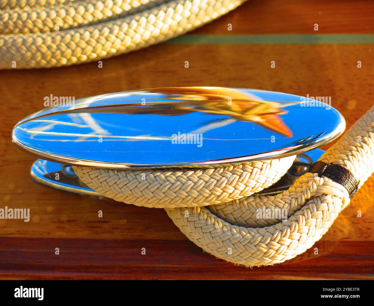 Stainless steel cleat on the varnished deck of a sailing dinghy Stock ...
