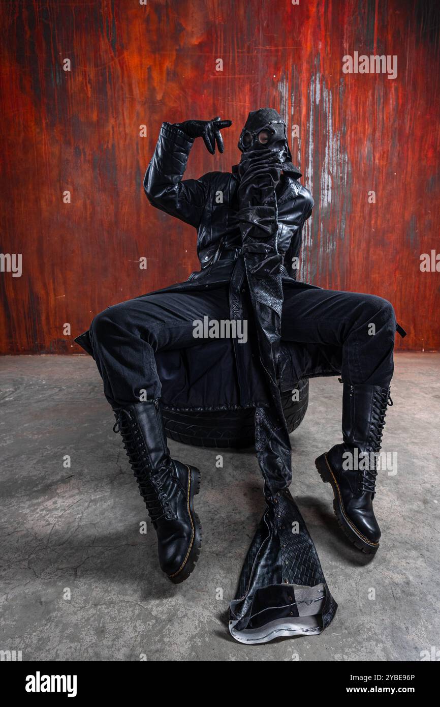 A strange post apocalyptic freak in a leather suit wearing a mask with ...