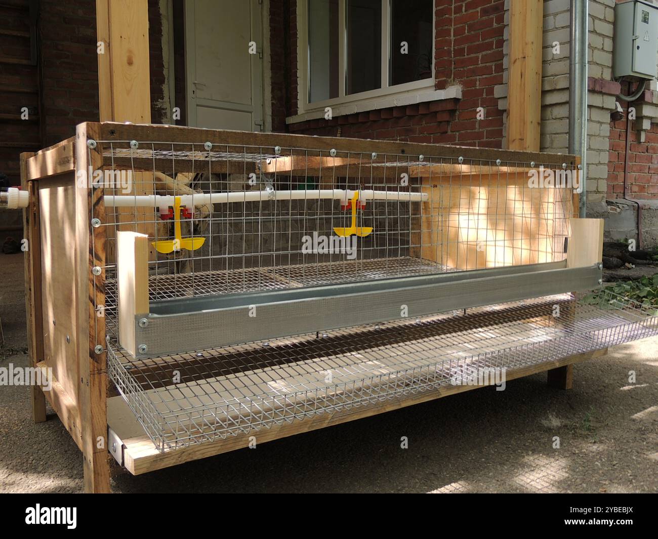homemade quail cage made of wood and mesh materials with a metal feeder ...