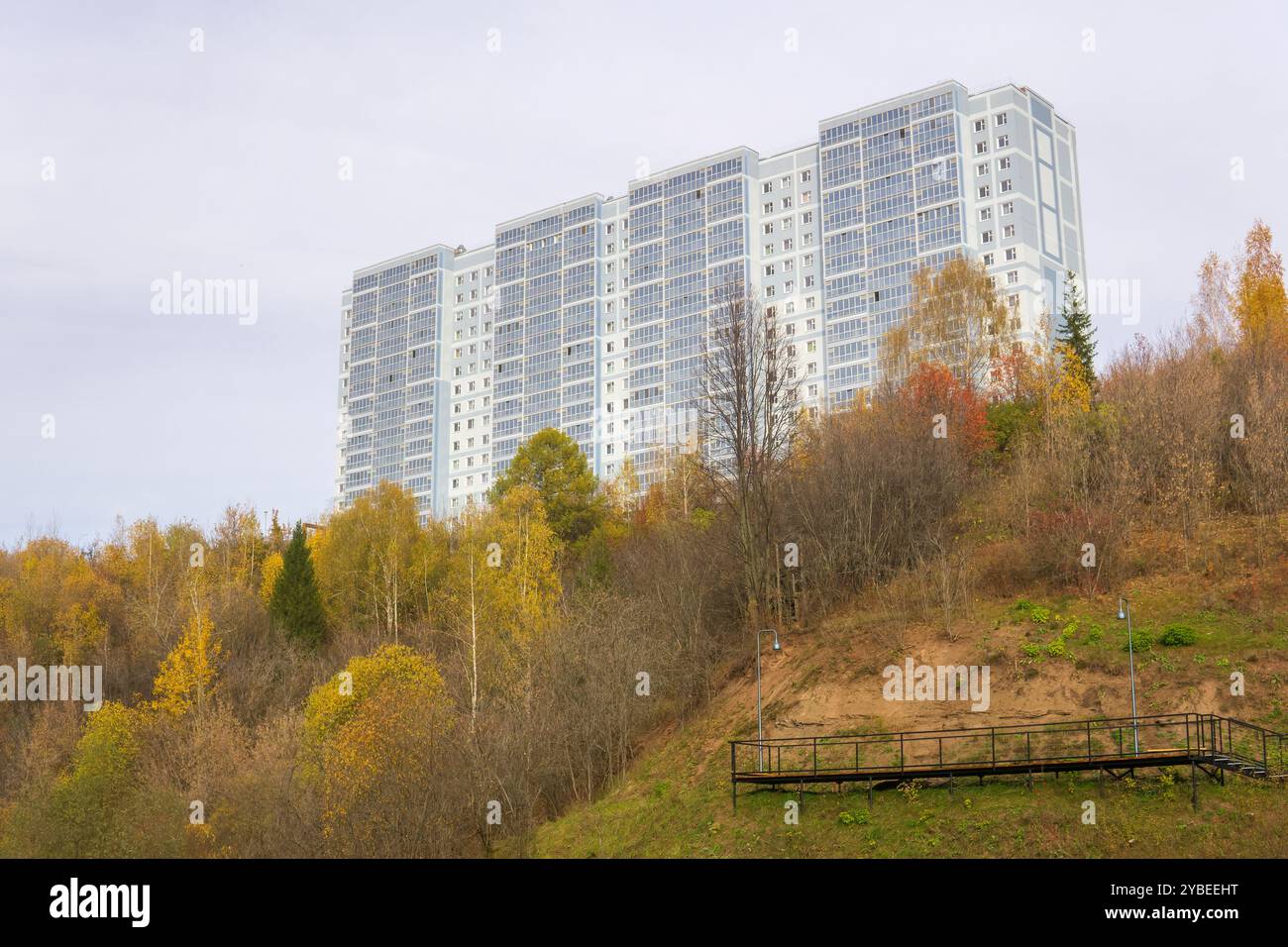 multi-story residential building on top of a hill with autumn trees ...
