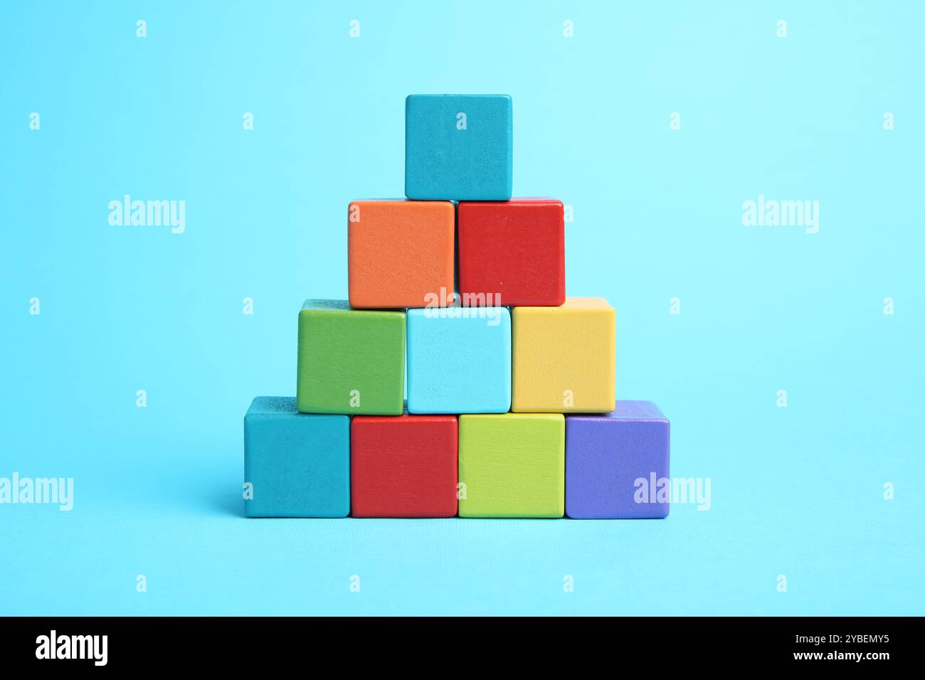 Pyramid of colorful cubes on light blue background Stock Photo - Alamy