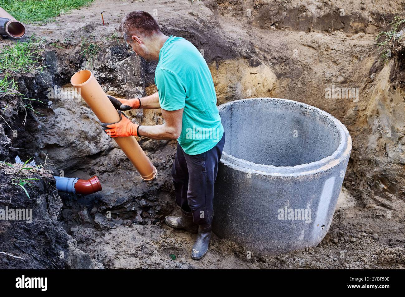 Wastewater plumbing work, plumber connects inlet sewer pipe to septic ...