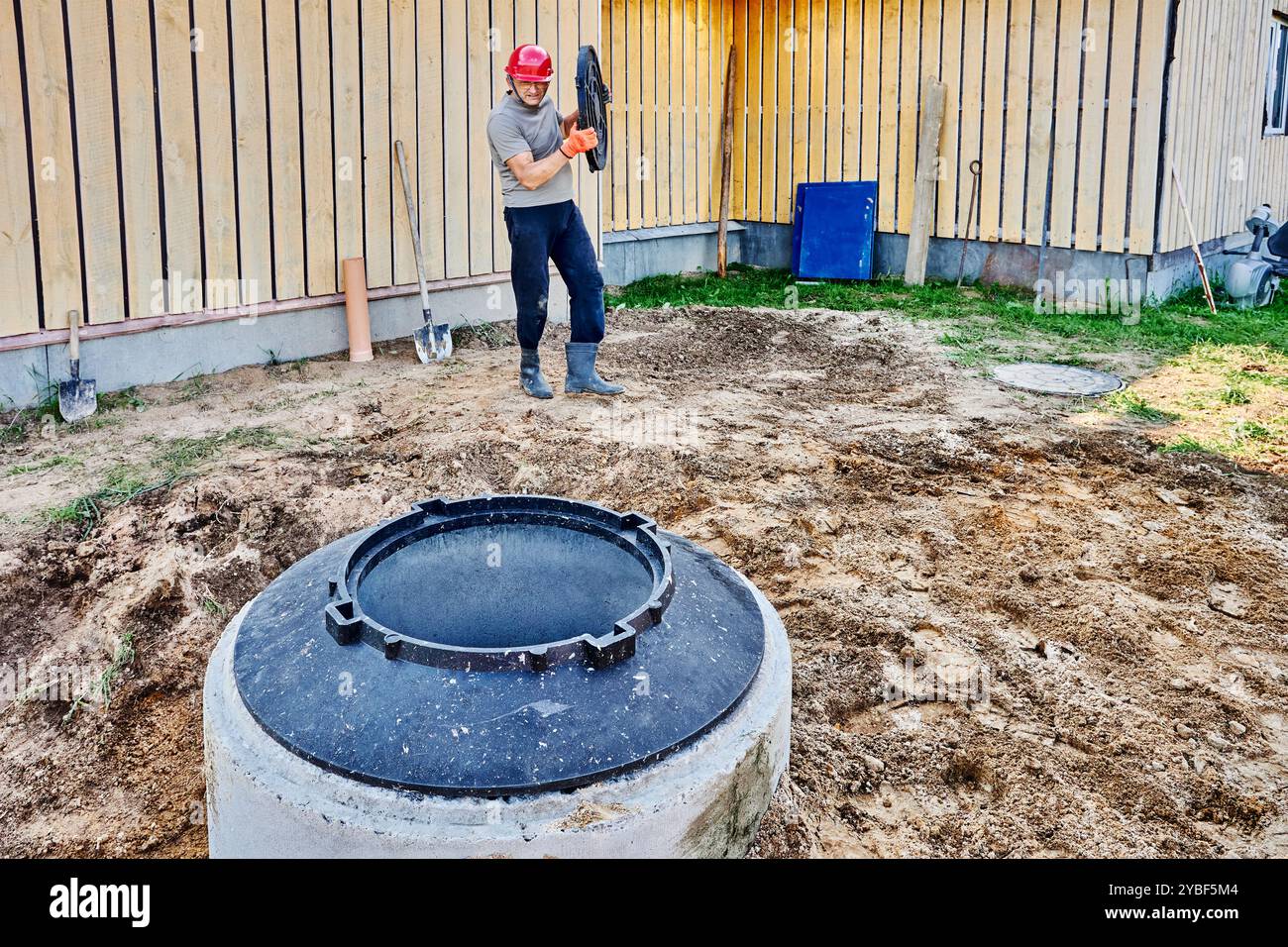 New septic tank made of concrete rings is installed on house territory ...