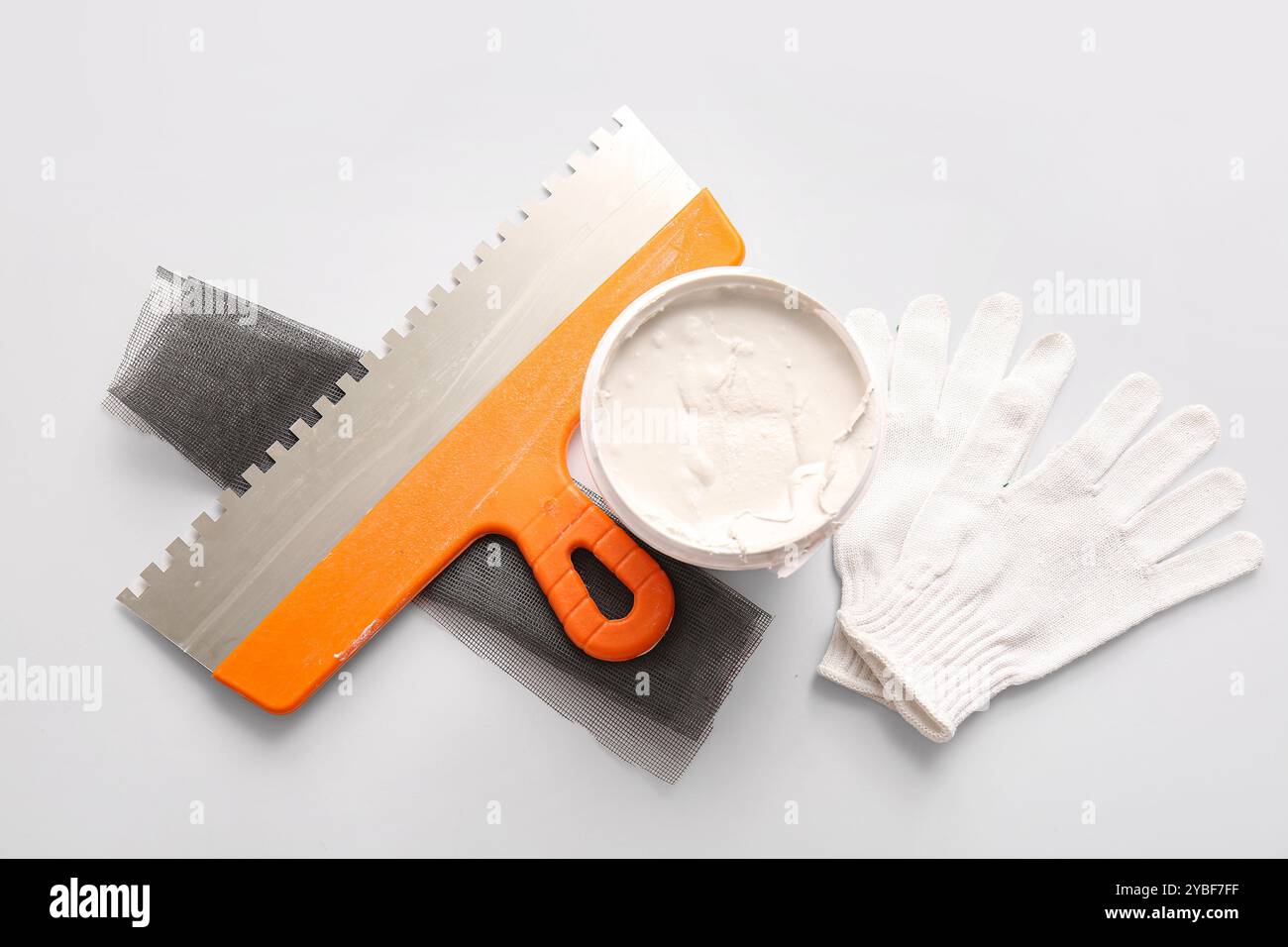 Knife, gloves, mesh and can of putty on white background Stock Photo ...