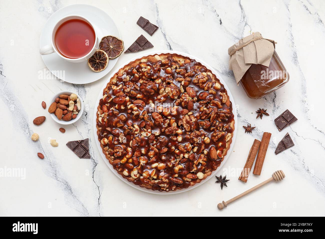 Sweet tart with different nuts and cup of tea on white background Stock ...