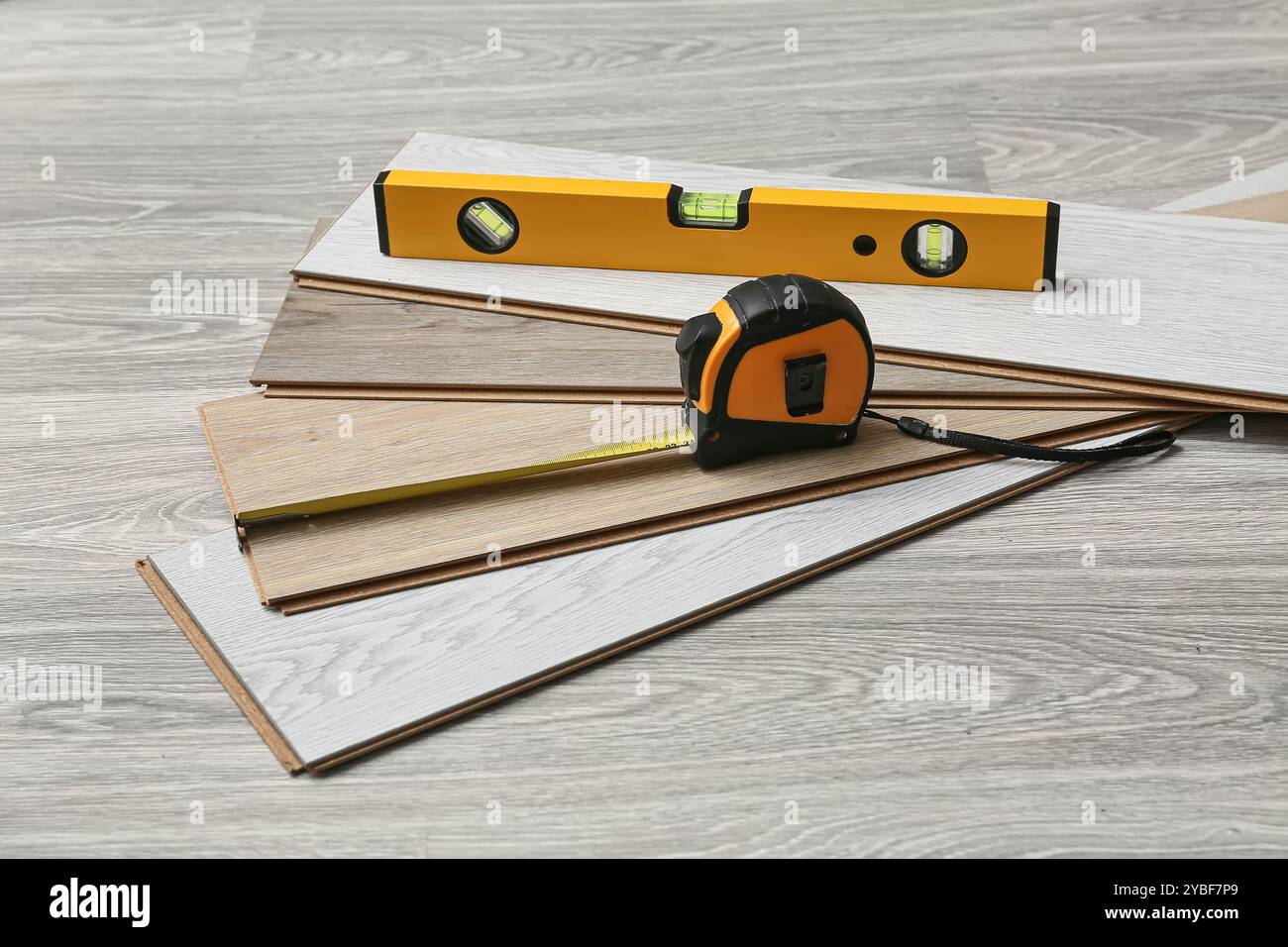 Measuring tape, spirit level and laminate boards on floor Stock Photo ...